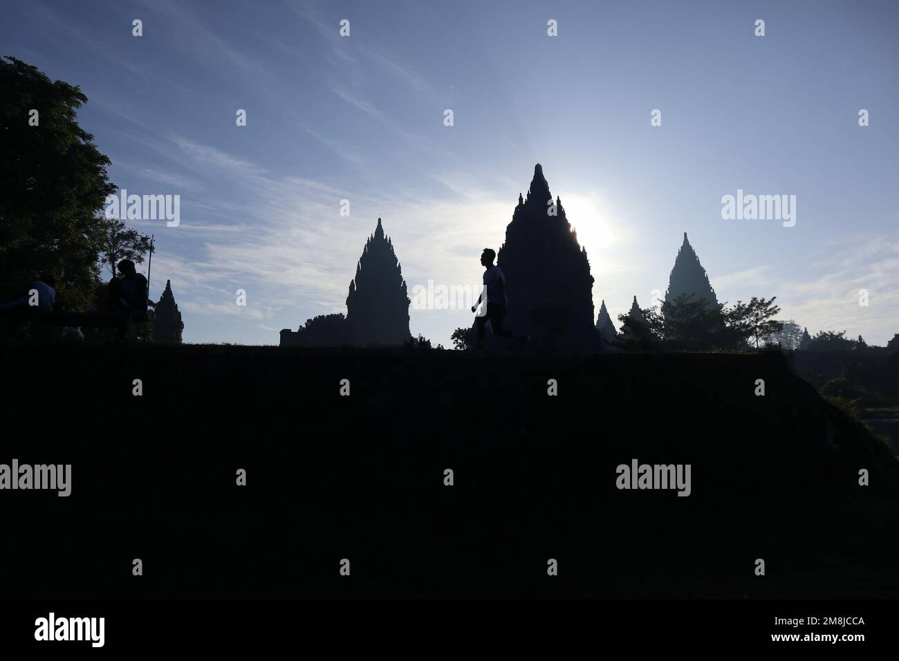 silhouette of a man running, jogging at Prambanan temple in the morning ...