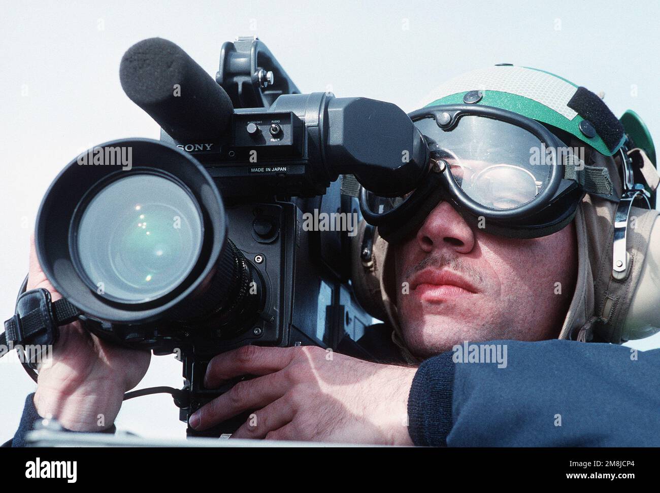 A Navy photographers mate videotapes flight deck operations on board ...