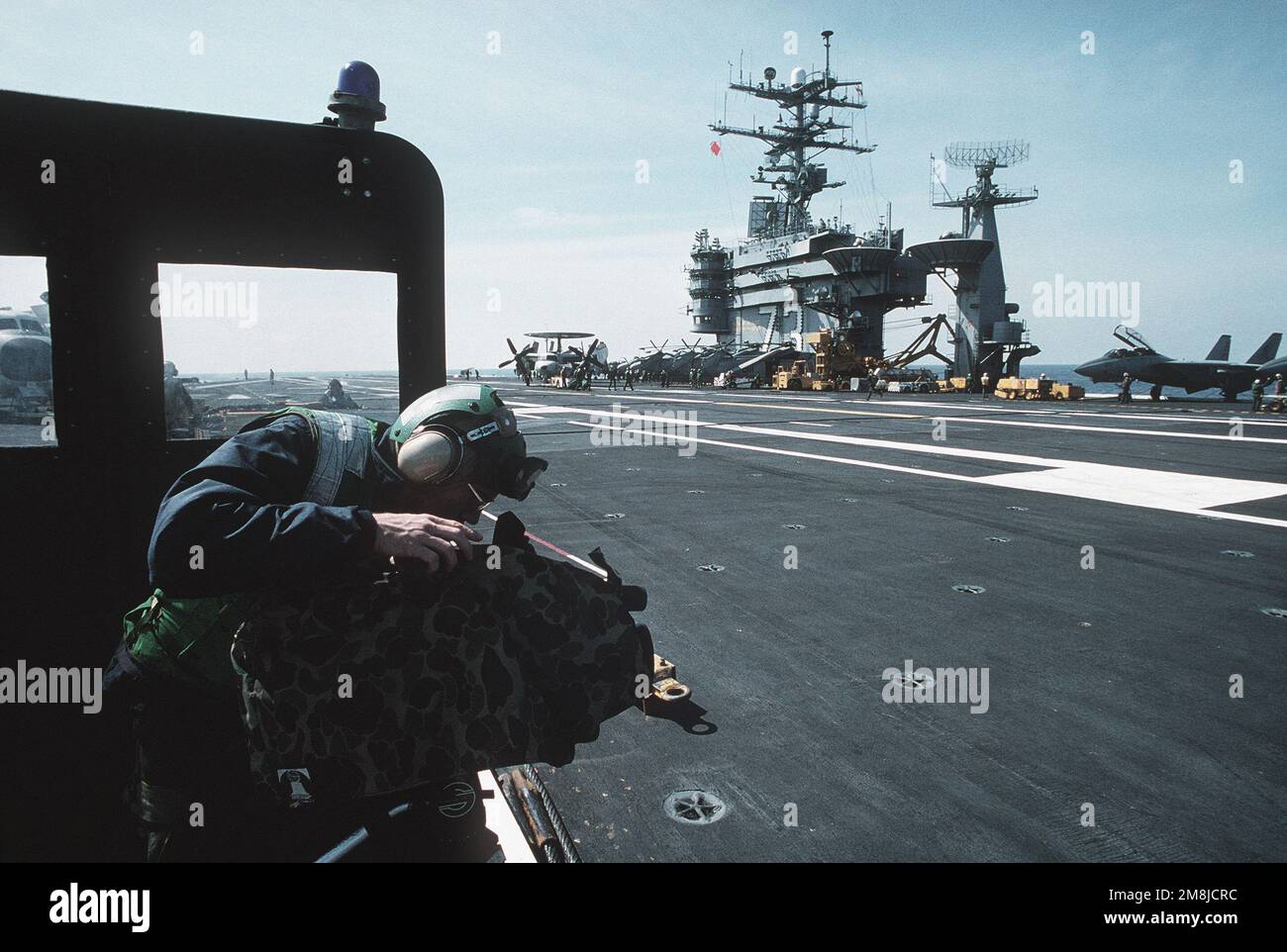 A Navy photographers mate videotapes flight operations from the Landing ...
