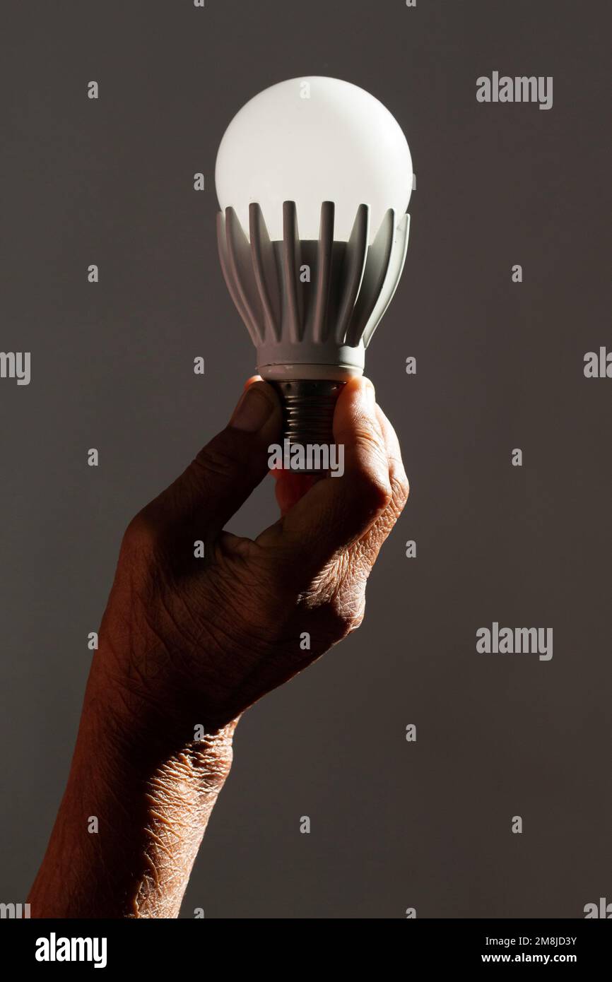 a light bulb being held in an old man's wrinkled hand Stock Photo - Alamy