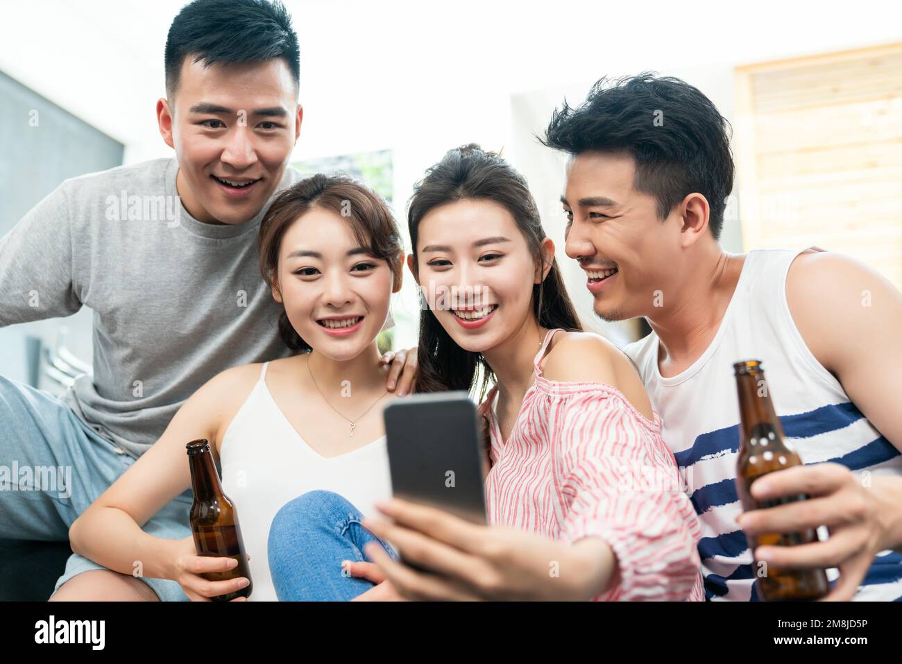 Young friends drink beer Stock Photo - Alamy
