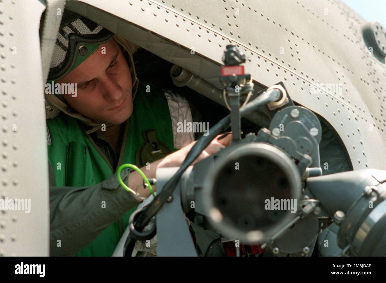 A squadron mechanic performs maintenance on an aircraft on board the ...