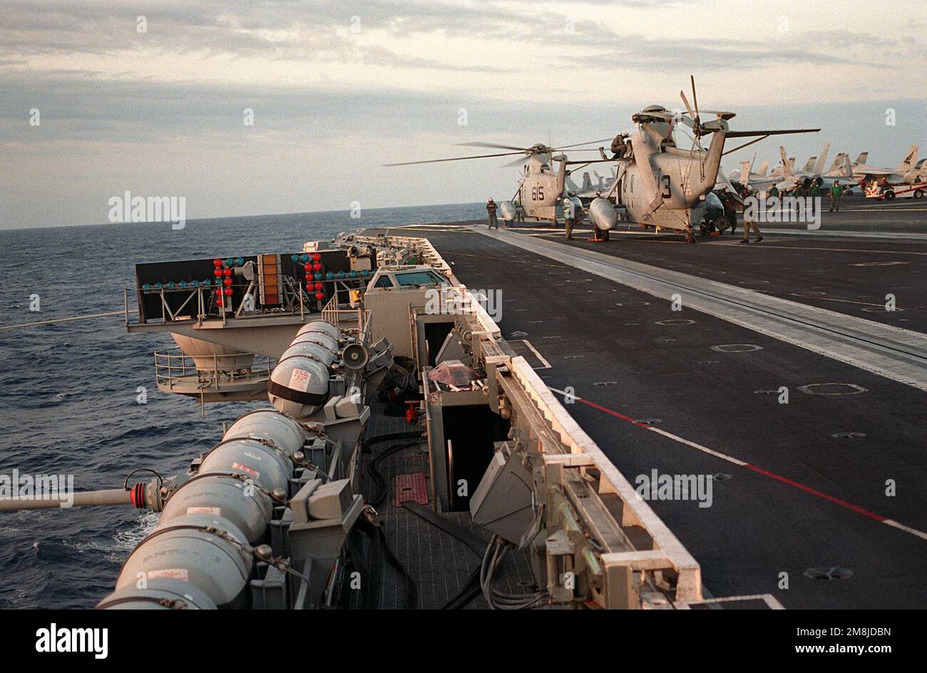 Two SH-3H Sea King helicopters are spotted on the flight deck of the ...