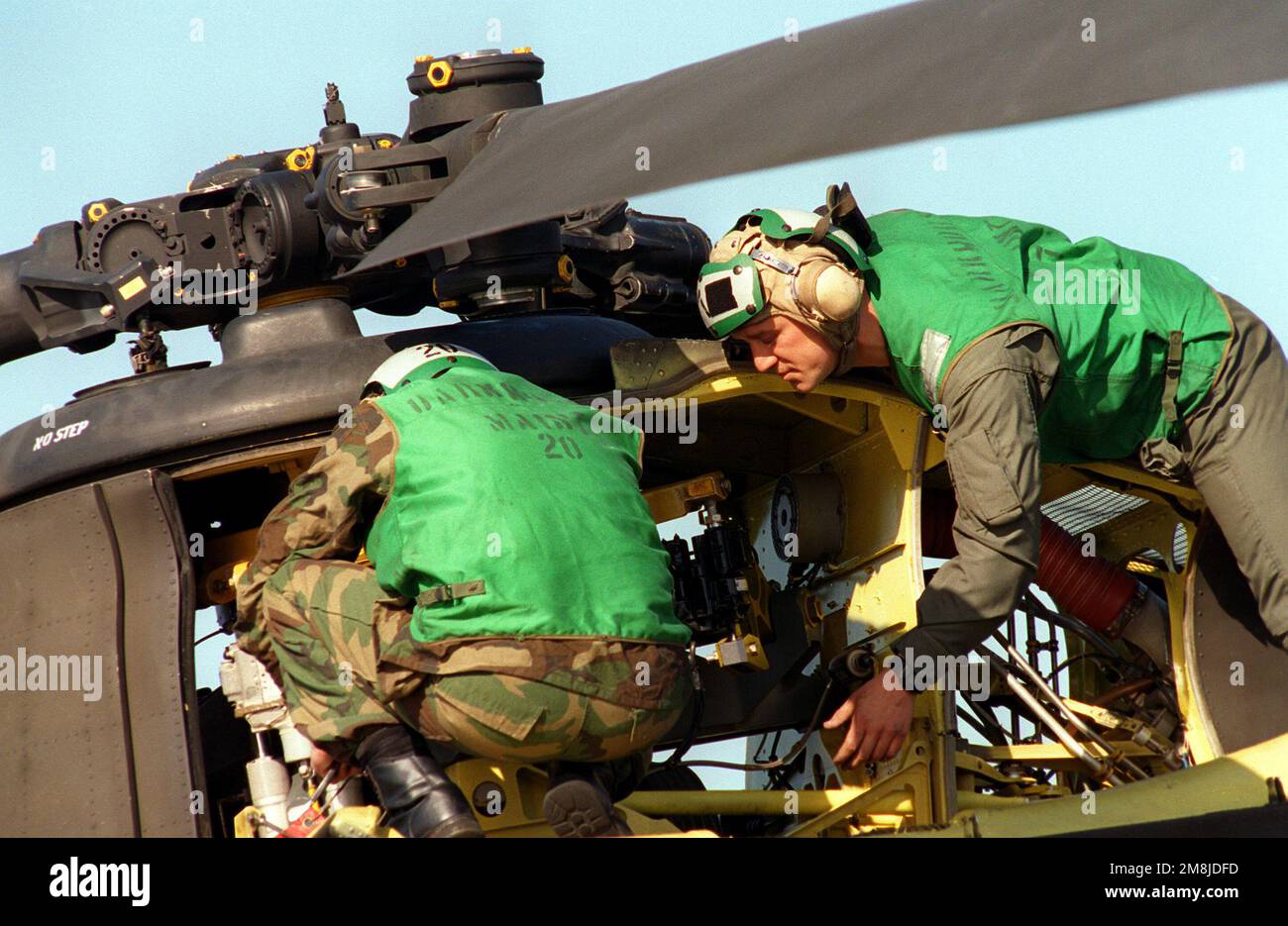 Army crewmembers perform maintenance in the rotor compartment of a MH ...