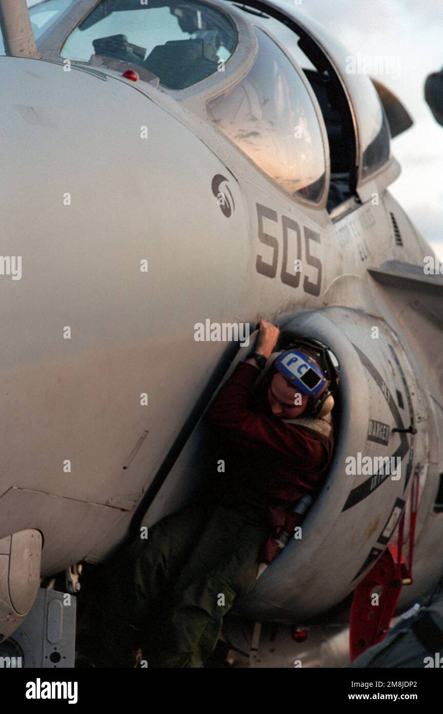 The plane captain of an A-6E Intruder aircraft crawls out of an intake ...