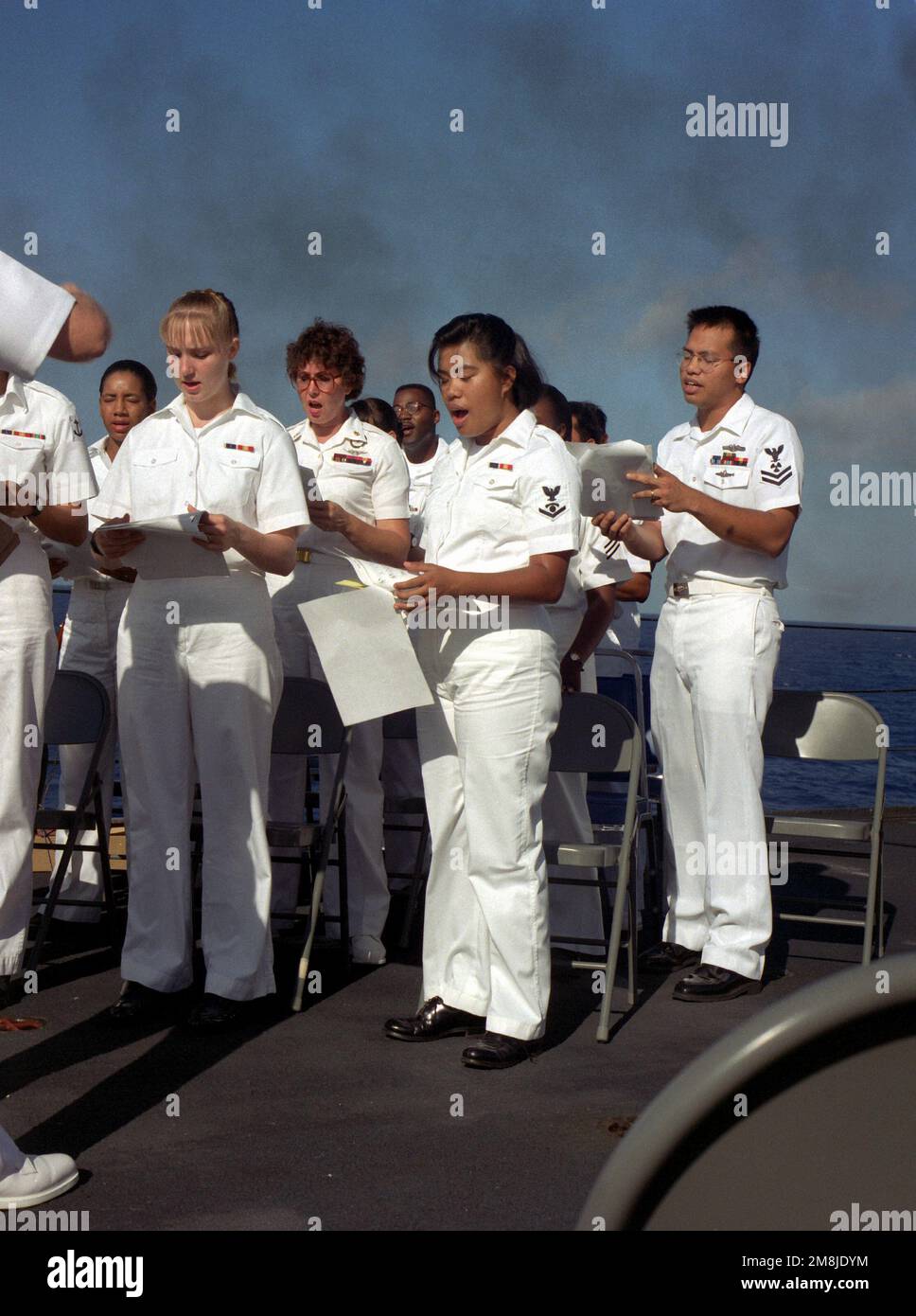 Members of the choir of the submarine tender USS HOLLAND (AS-32) sing ...