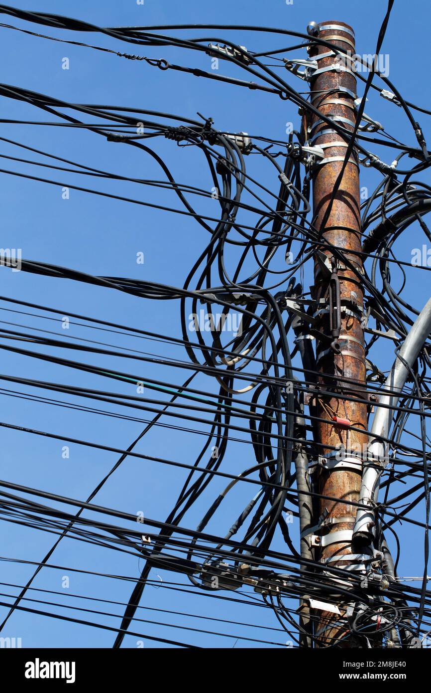 chaotic and crowded power lines on a blue sky background Stock Photo ...