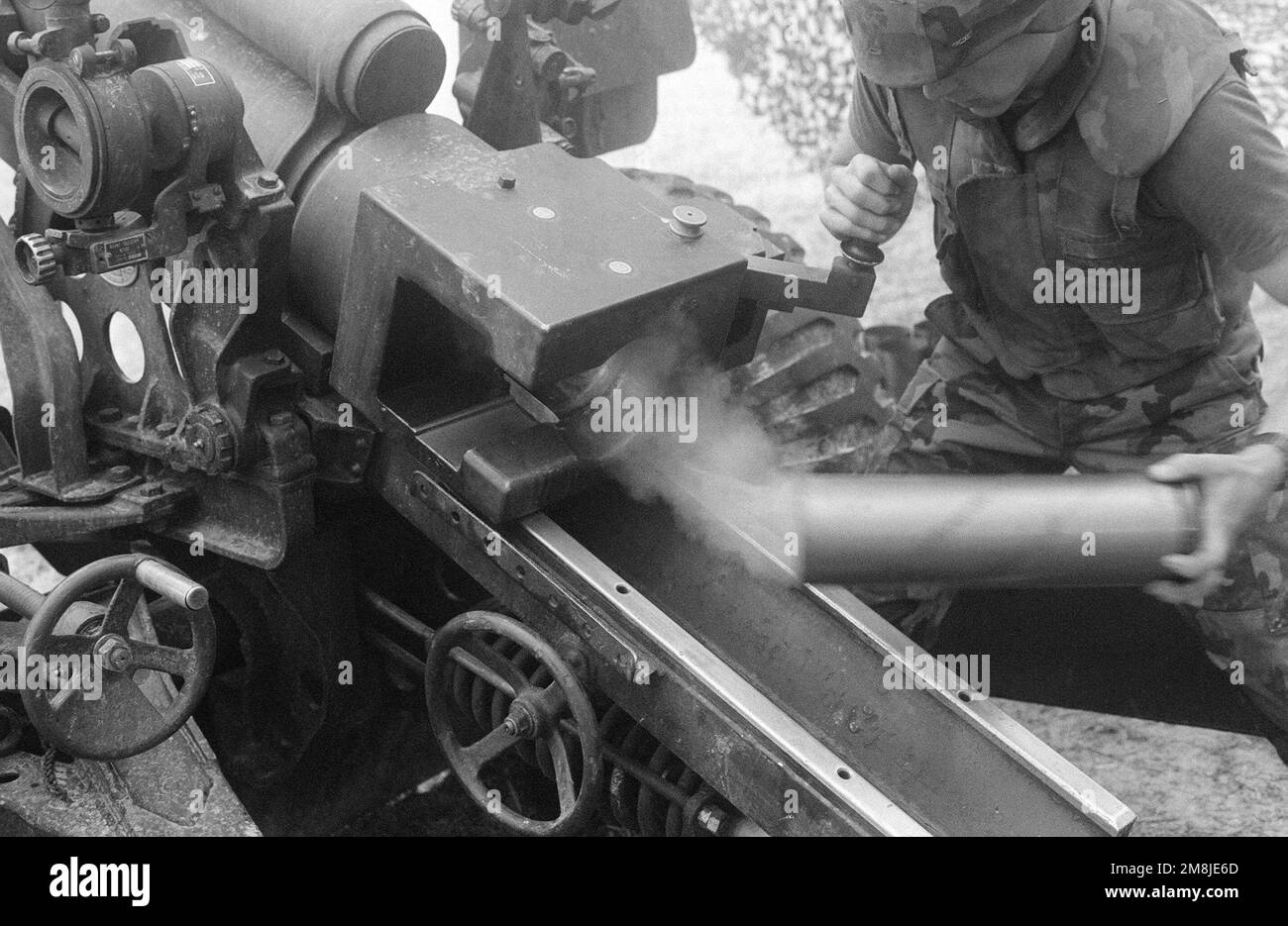 A Marine artilleryman removes a spent round from the breech of an M114 ...
