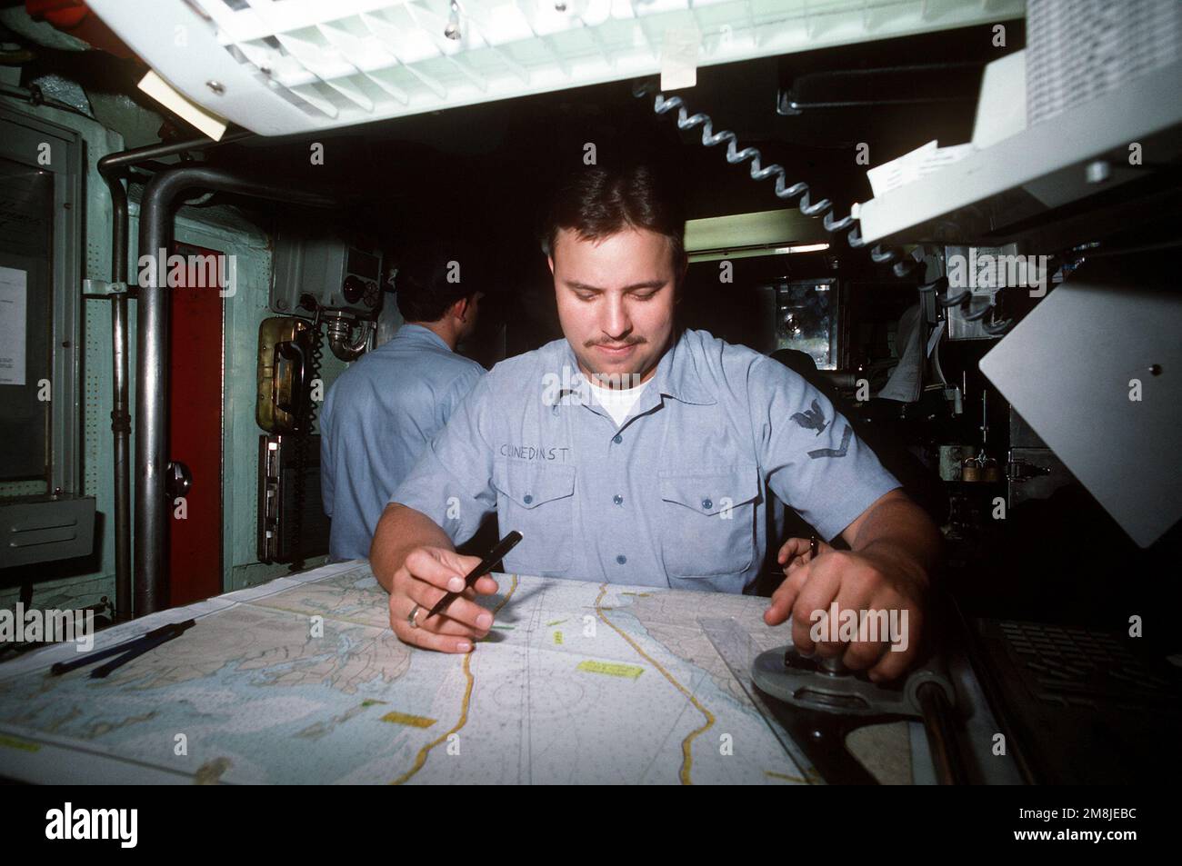 Quartermaster Third Class (QM3) Winston Clinedinst plots the course up ...