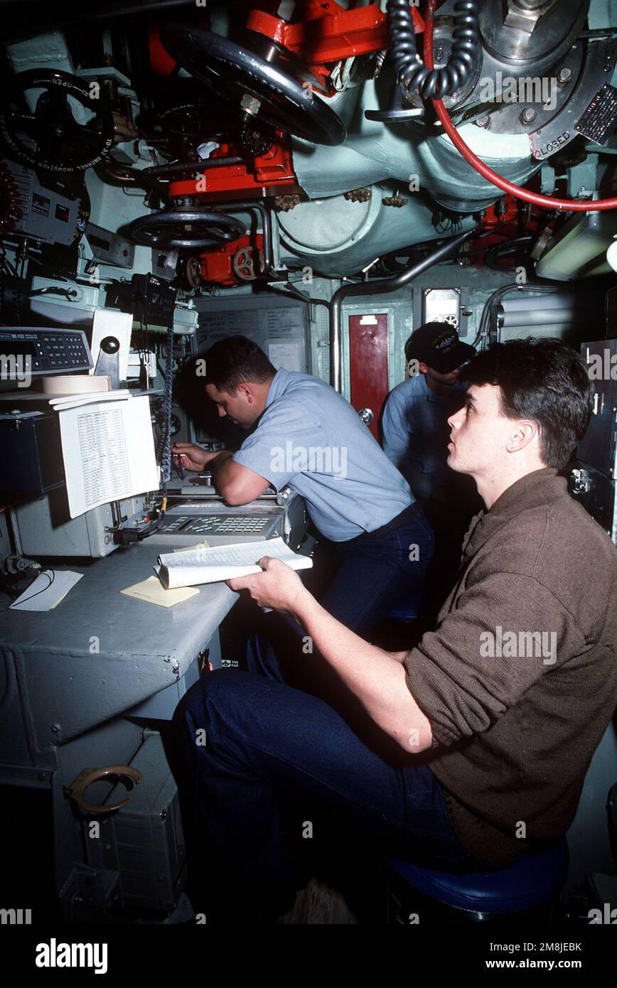 Quartermaster Third Class (QM3) Ronald Weaver stands the navigational ...