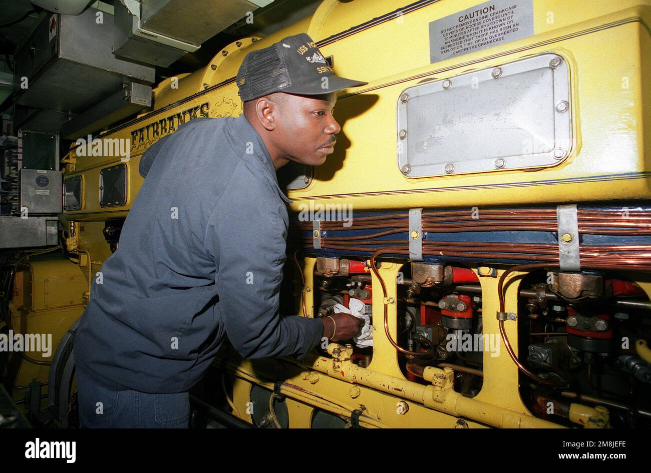 Machinist Mate First Class (MM1) Prince Stokley cleans the auxiliary ...