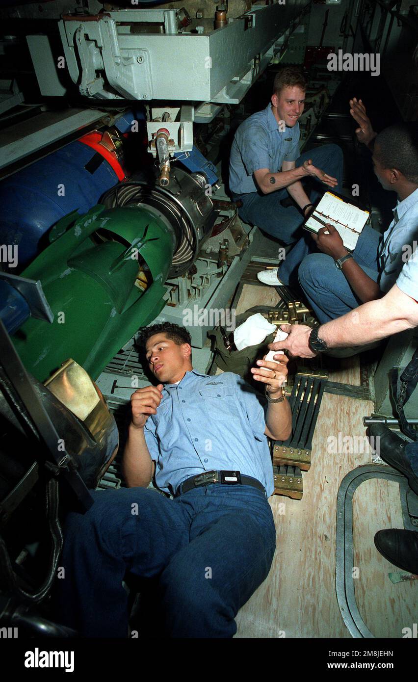 Torpedoman Third Class (TM3) Kurt Lopez attaches an "A" cable to an ...