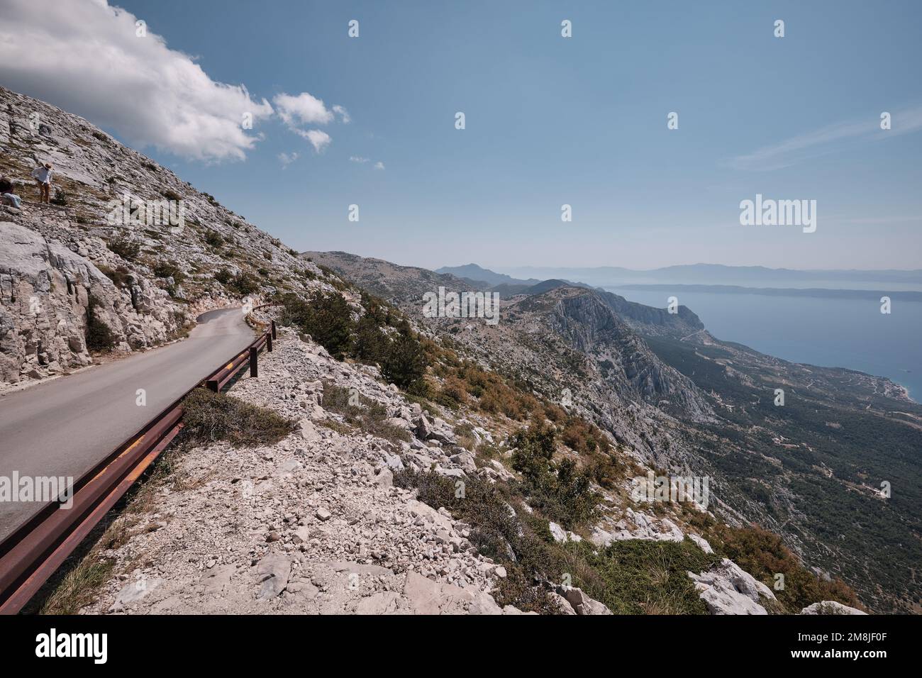 A steep and narrow mountain road overlooking mountains and a vally ...