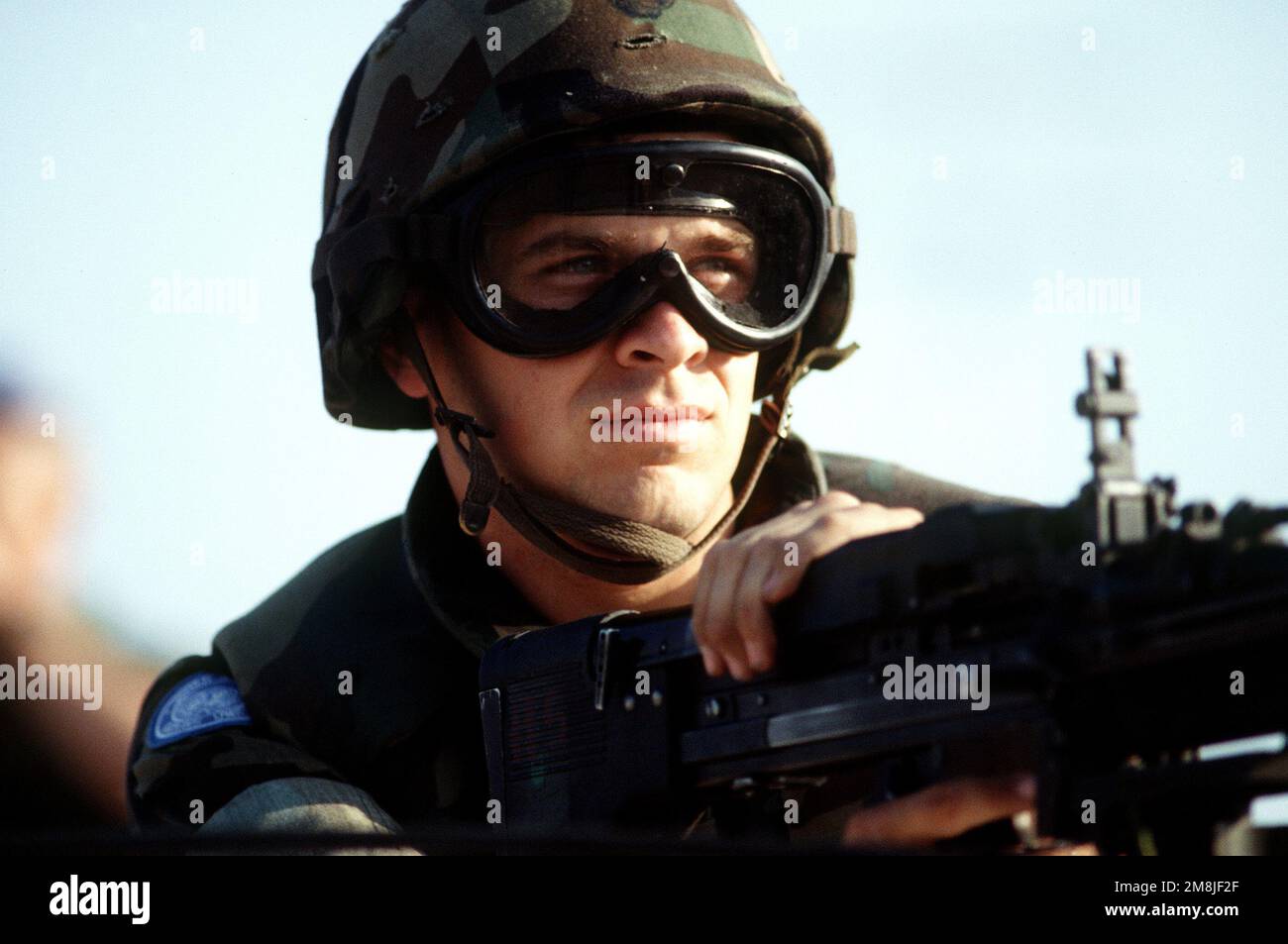 A close up view of a US Marine as he grips his machine gun to provide a ...