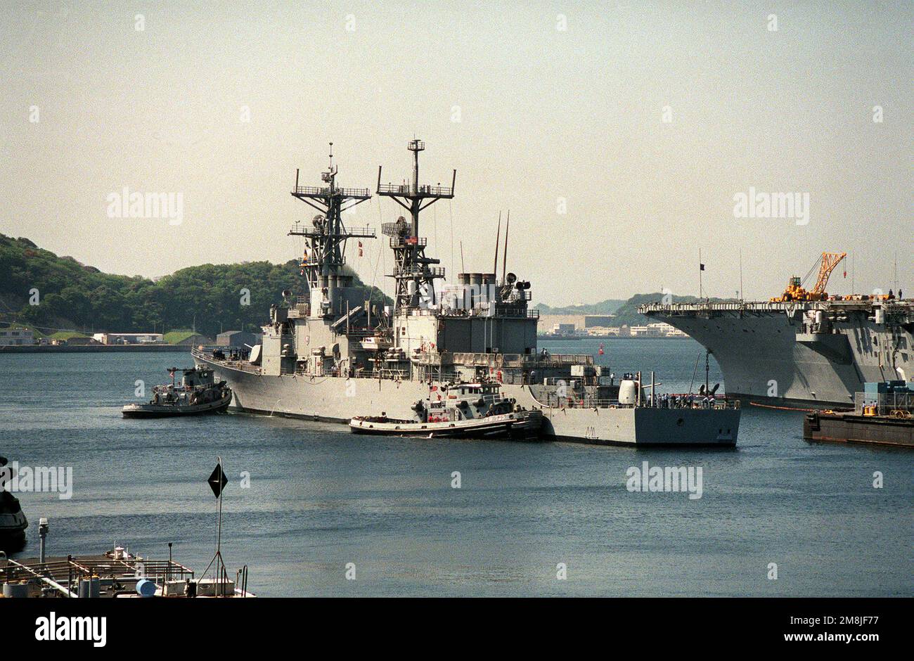 A port quarter view of the destroyer USS HEWITT (DD-966) being assisted ...