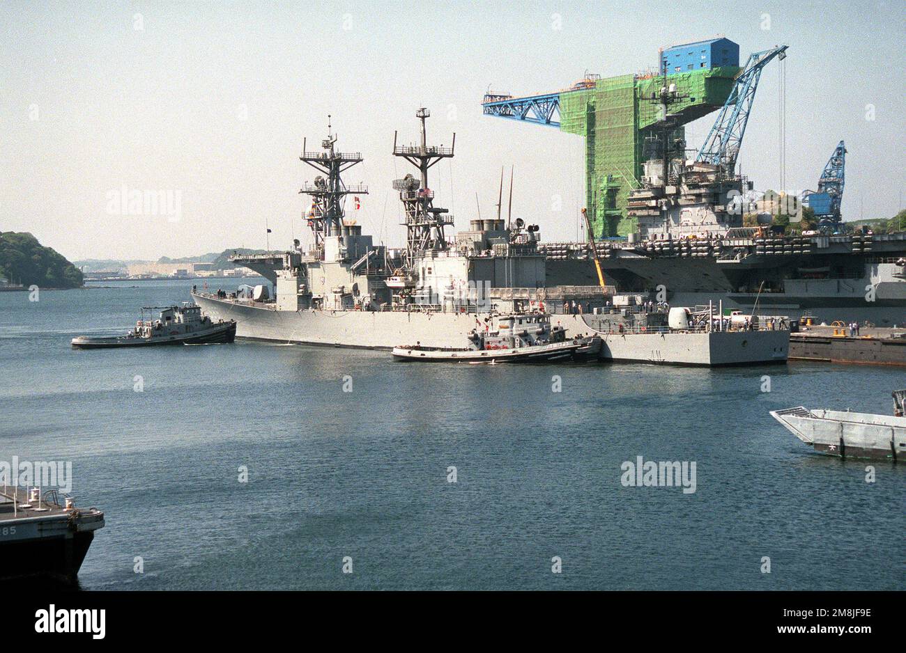 A port quarter view of the destroyer USS HEWITT (DD-966) being assisted ...
