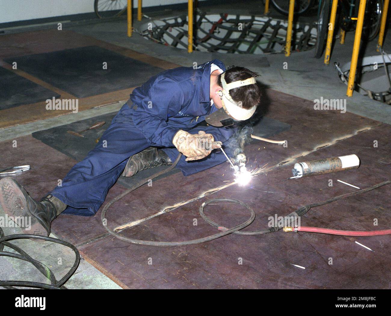 Hull Maintenance Technician Second Class (HT2) Joseph E. Bailey welds a ...