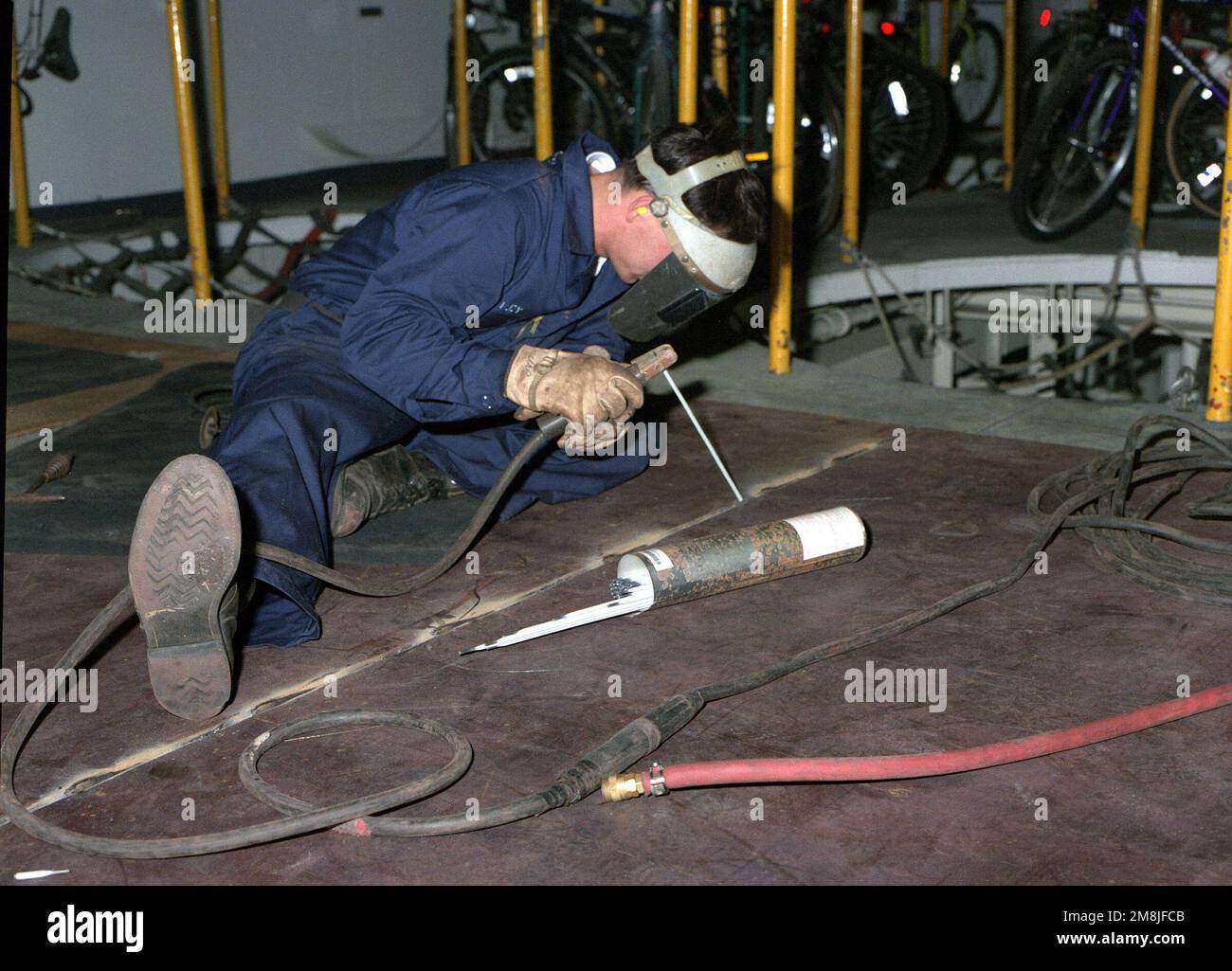 Hull Maintenance Technician Second Class (HT2) Joseph E. Bailey welds a ...