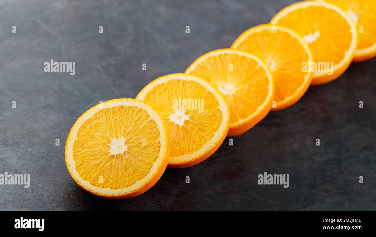 Orange slices on a black background. Halves of juicy oranges for a ...