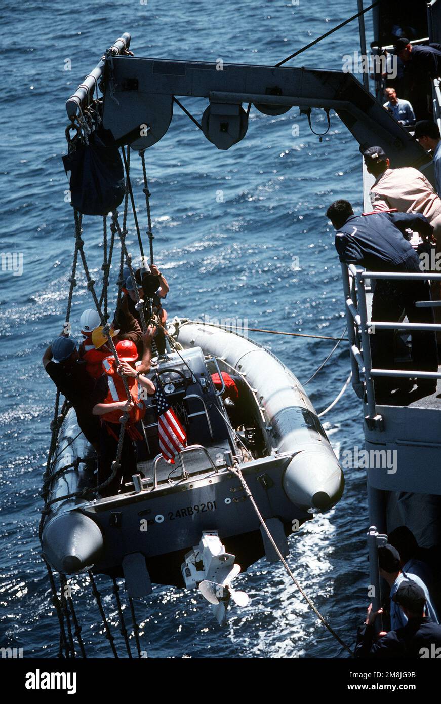 The 24 foot rigid rubber boat is hoisted back on board the guided ...