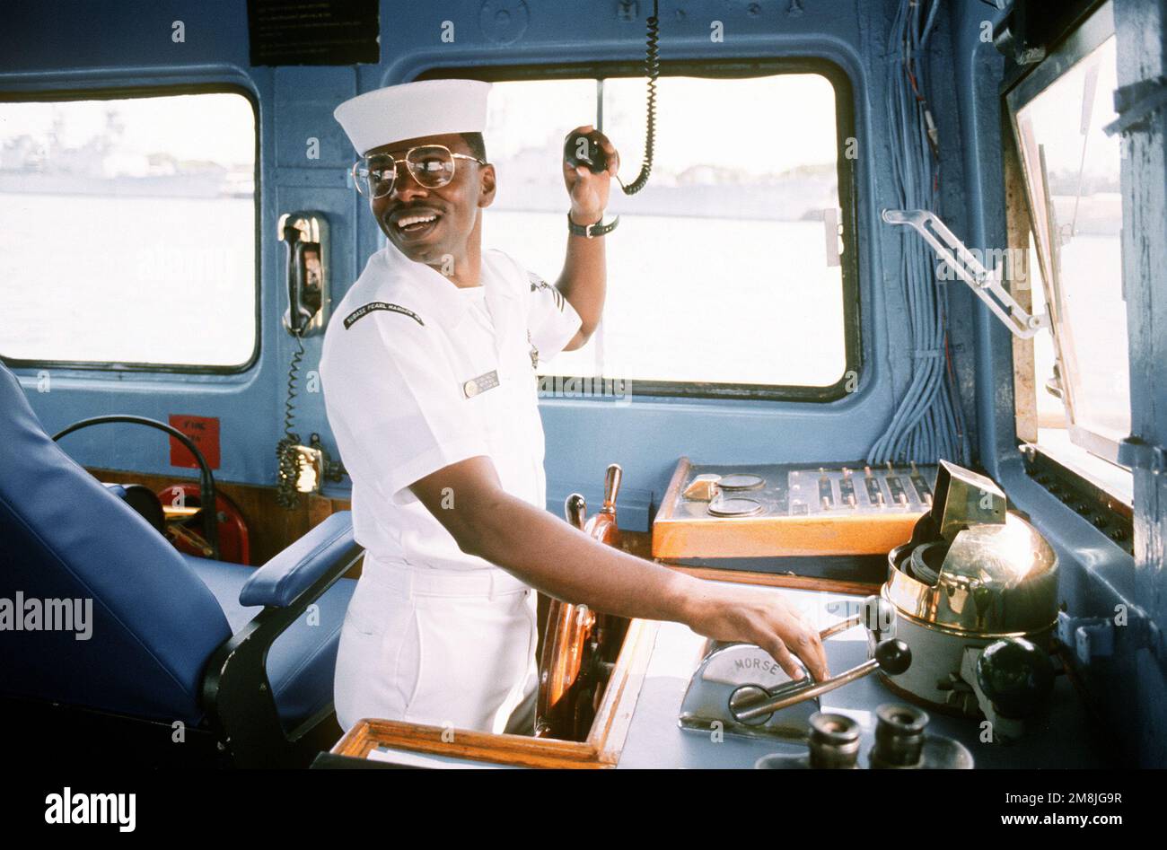 Quartermaster First Class (QM1) Herbert Kelton mans the helm of torpedo ...
