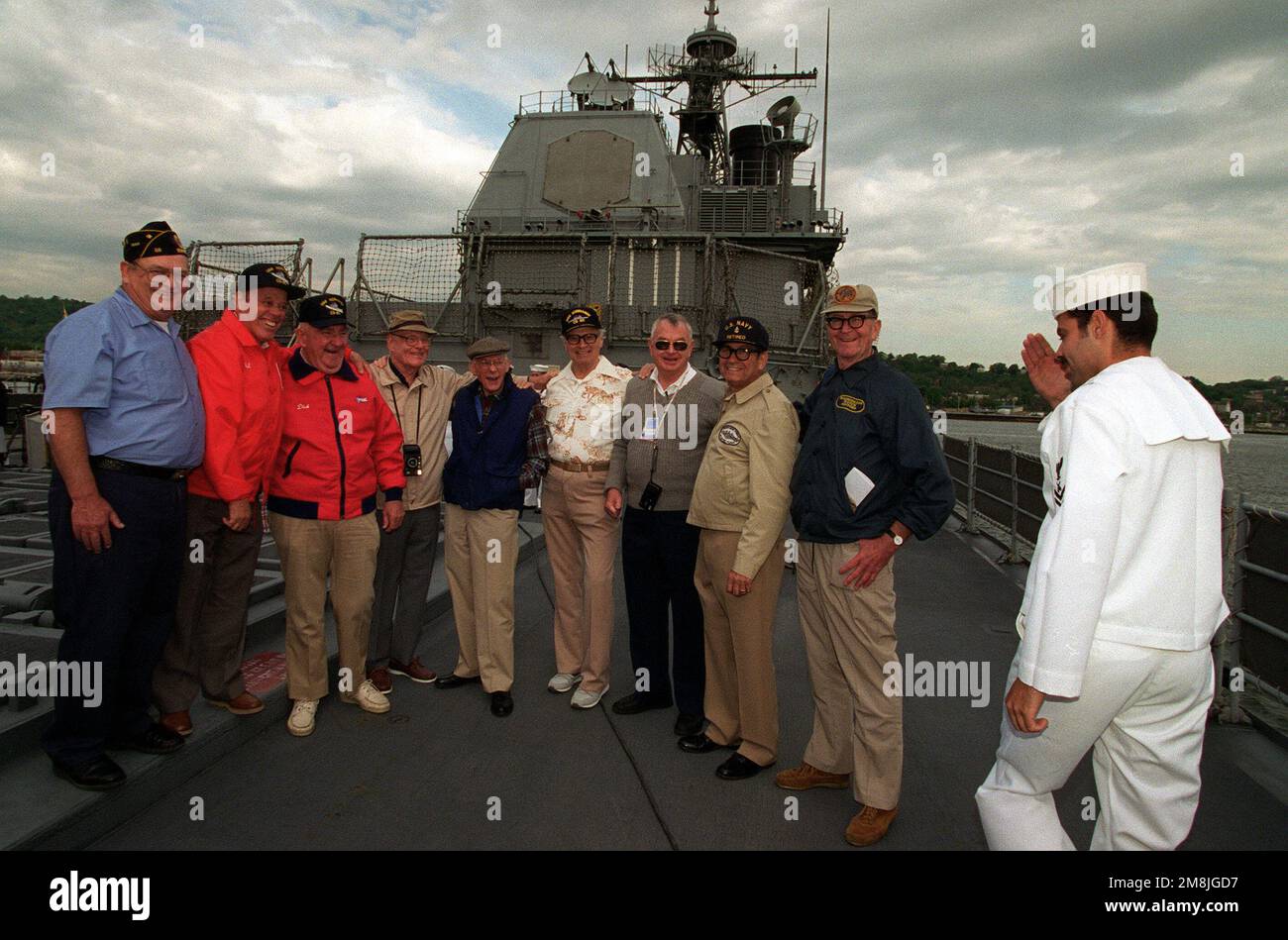 A crewmember of the guided missile cruiser USS NORMANDY (CG-60) salutes ...