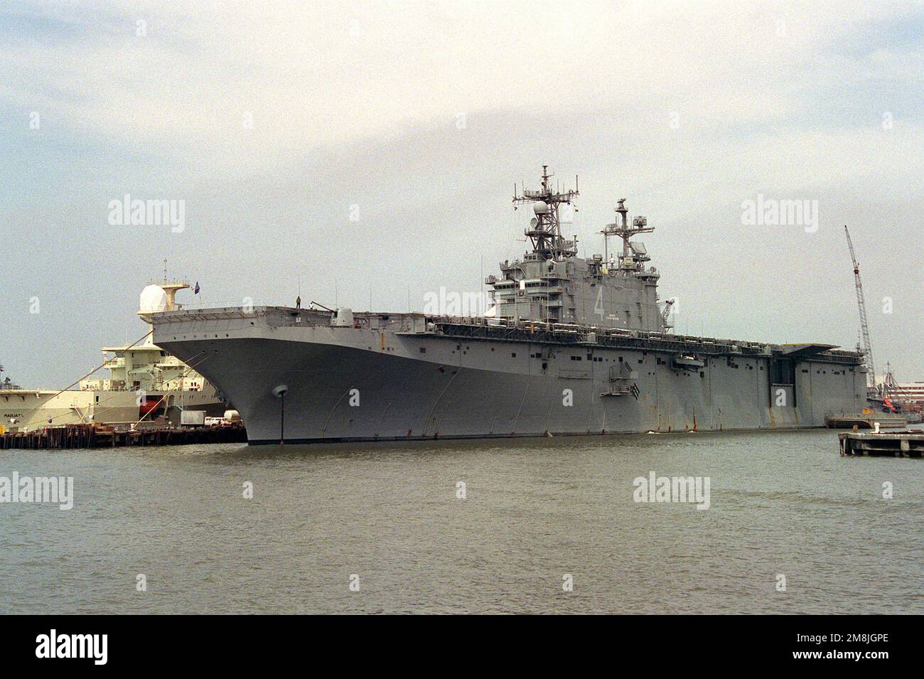 A port bow view of the amphibious assault ship USS NASSAU (LHA-4) tied ...