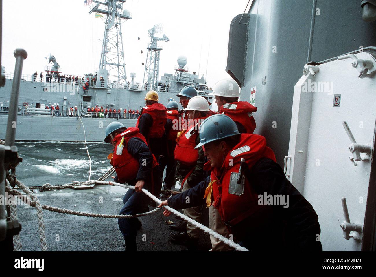 Line handlers aboard the destroyer USS HAYLER (DD-997) man the lines ...