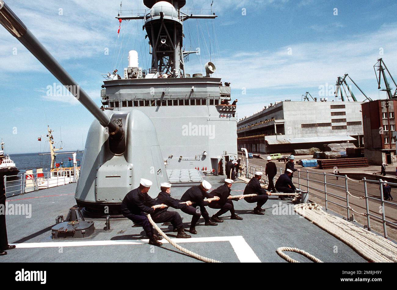 Sailors haul in mooring lines on the bow of the destroyer USS HAYLER ...