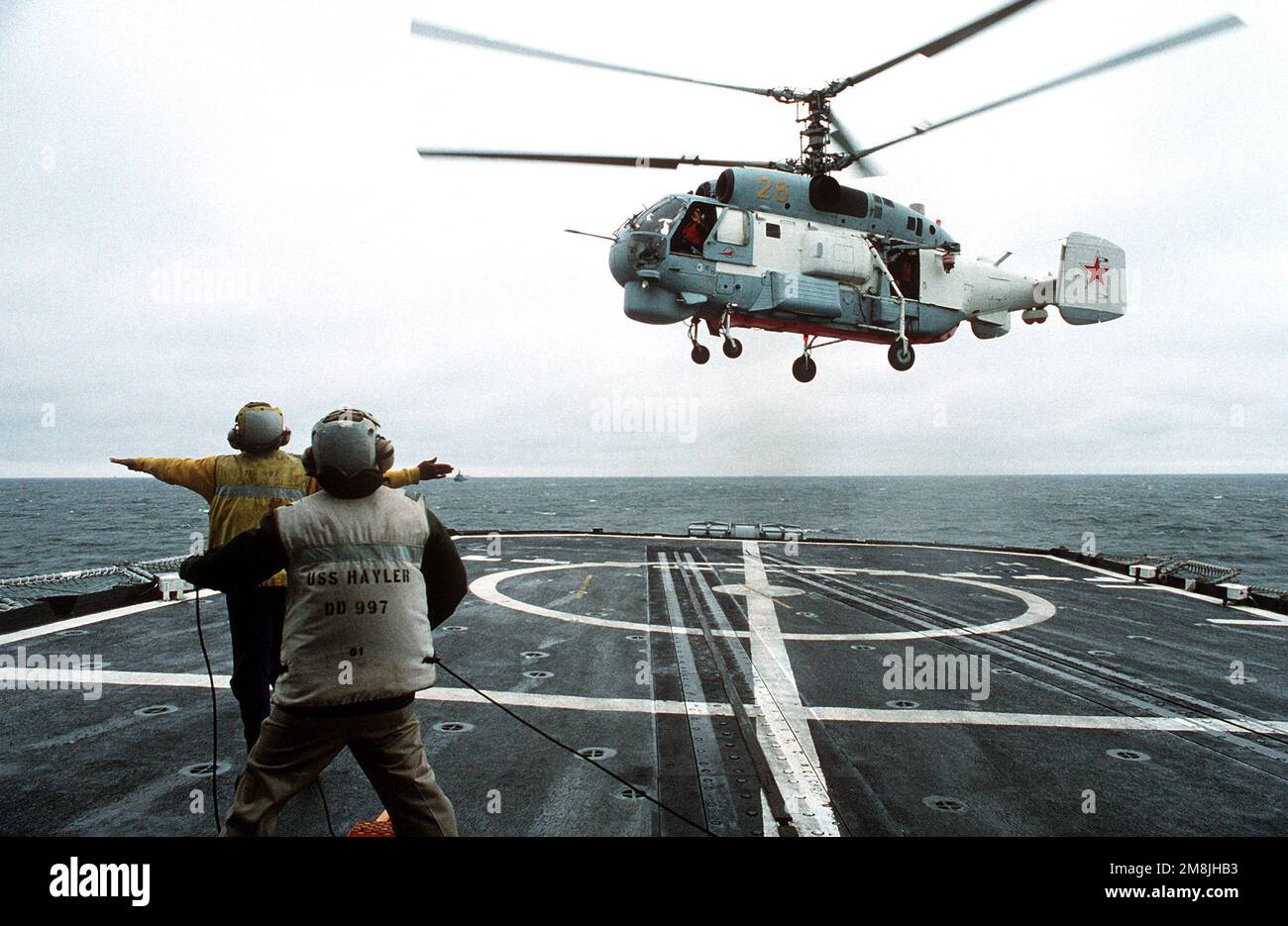 A flight deck controlman on the destroyer USS HAYLER (DD-997) signals ...