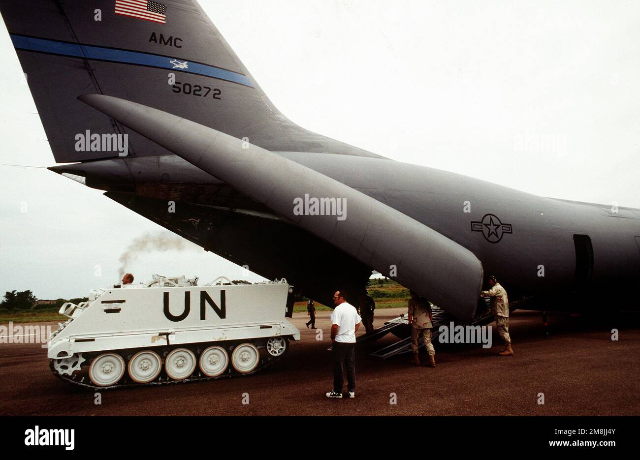 An M-113A2 rolls out of a U.S. Air Force C-141 Starlifter and onto the ...