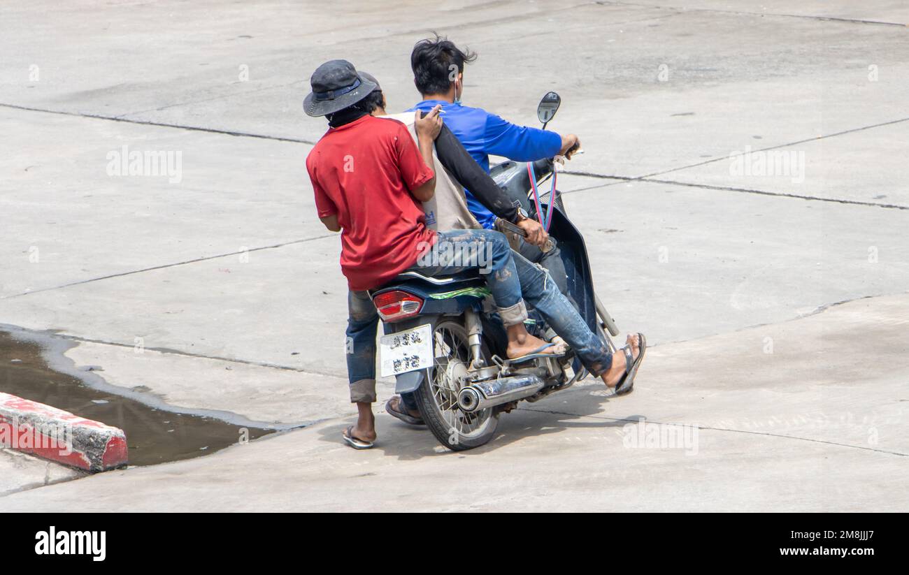A team of construction workers ride together on one motorcycle ...