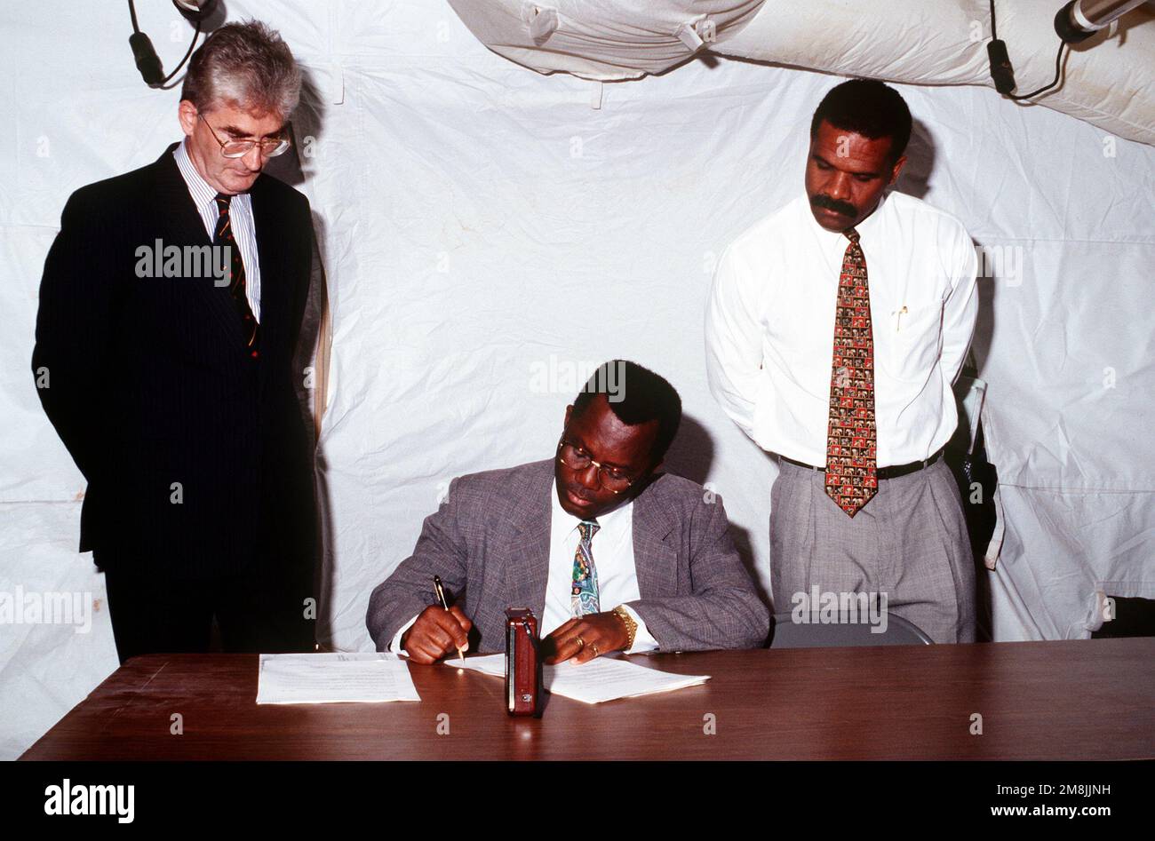 Robert Hall, Minister of Immigration, Labor and Works, signs the ...
