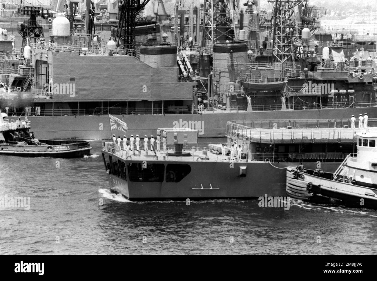A commercial tugboat assists in the docking of the Japanese Maritime ...