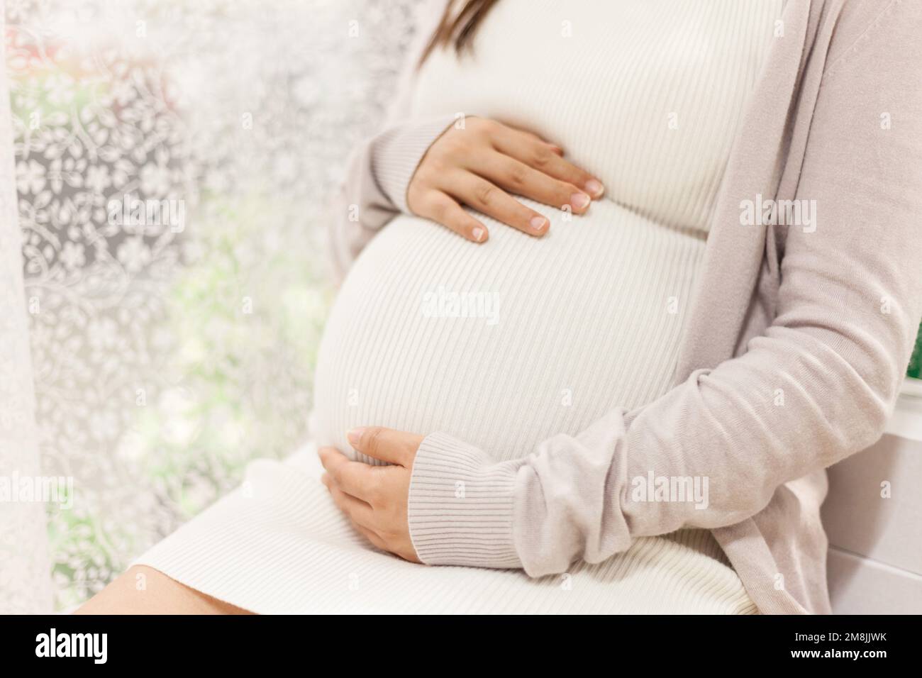 A pregnant woman sitting in a chair to rest Stock Photo - Alamy