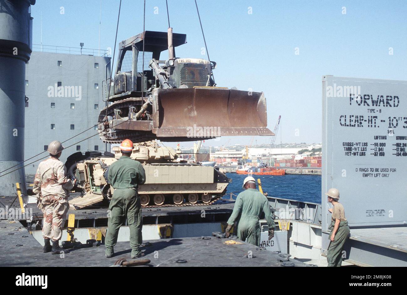 A D11 bulldozer is uploaded to the aft cargo hold of the USNS Denebola ...