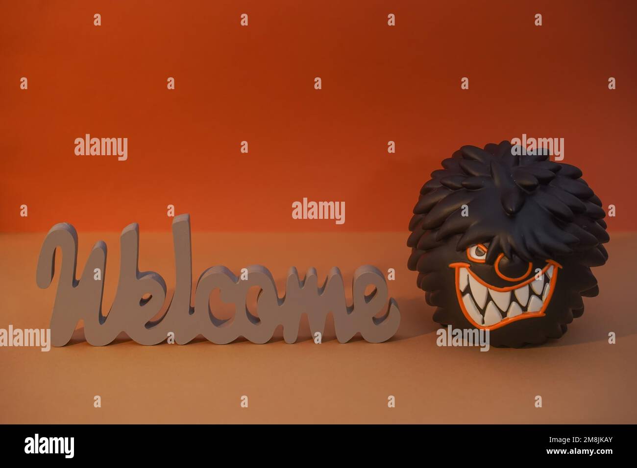 WELCOME wood inscription and shaggy hungry monster with huge teeth ...