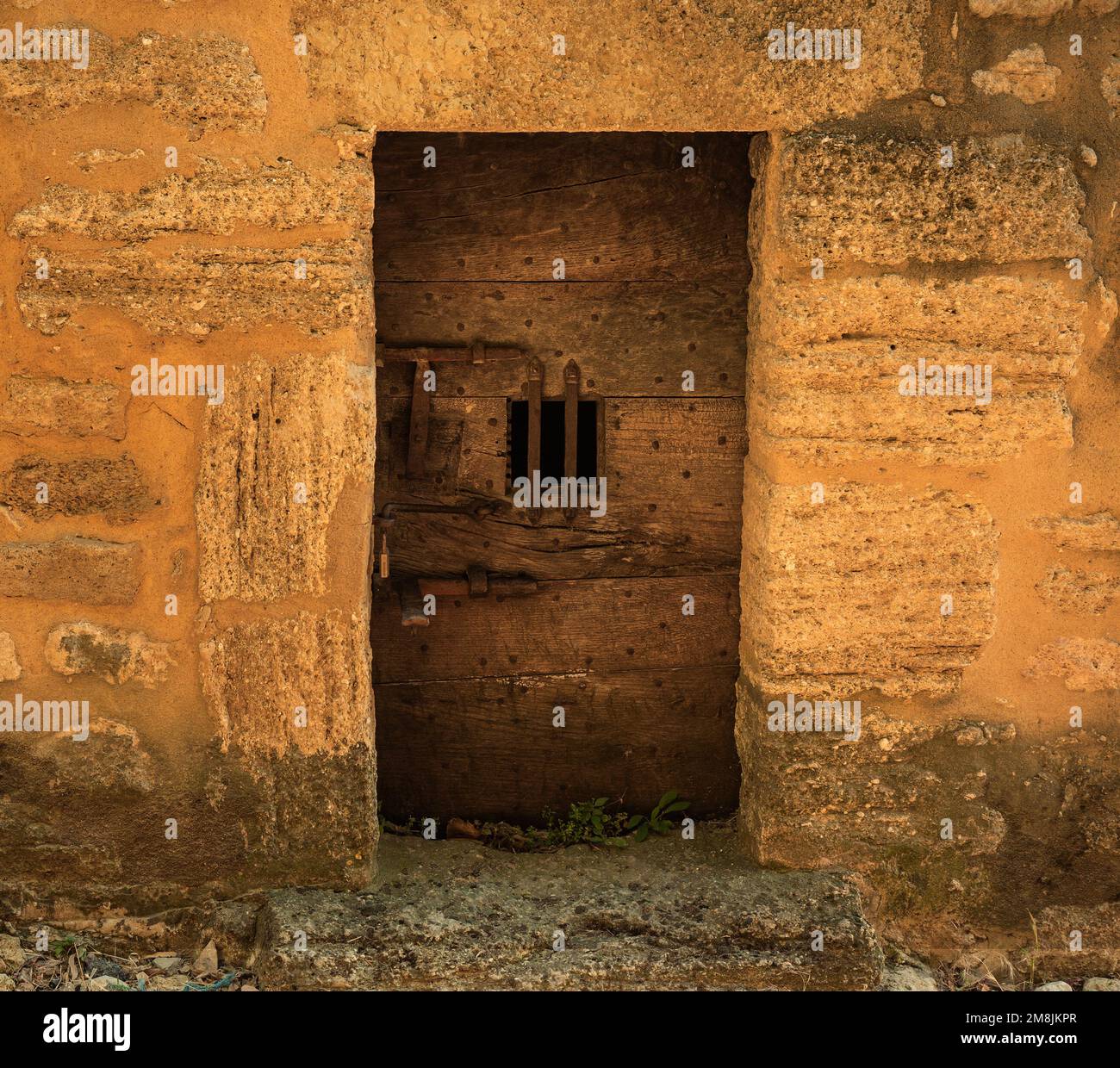 door of an ancient abandoned prison built in wood with an iron bolt and ...