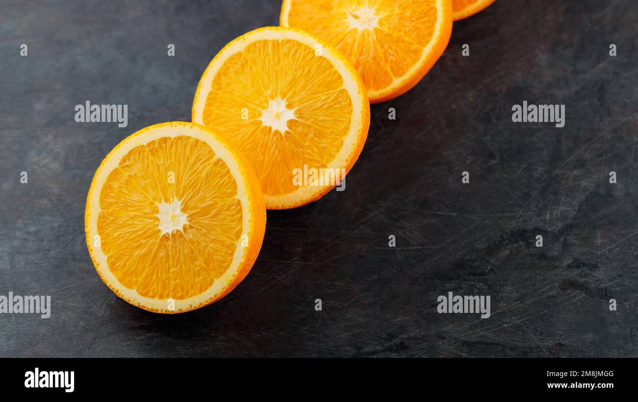 Halves of ripe oranges on a dark background. Sliced oranges for ...