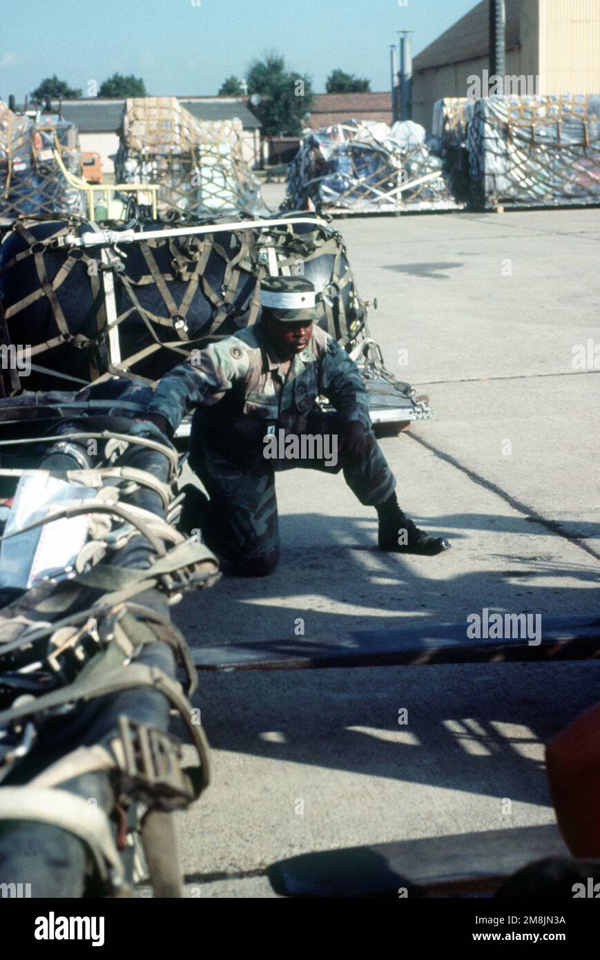 A security policeman kneels down as part of his security of the pallets ...