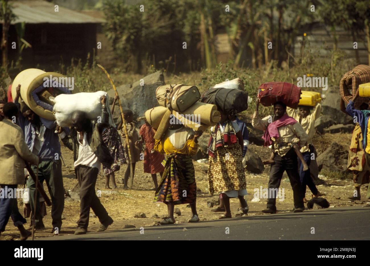 A stream of Rwandan refugees, carrying all their possession, walk into ...