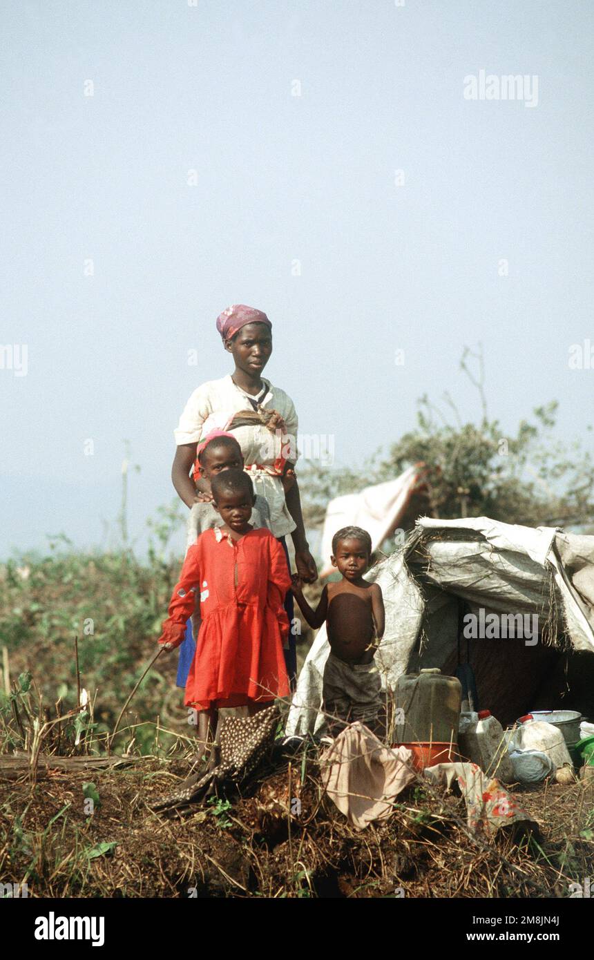 Rwandan refugee family of mother and children stand by a makeshift ...
