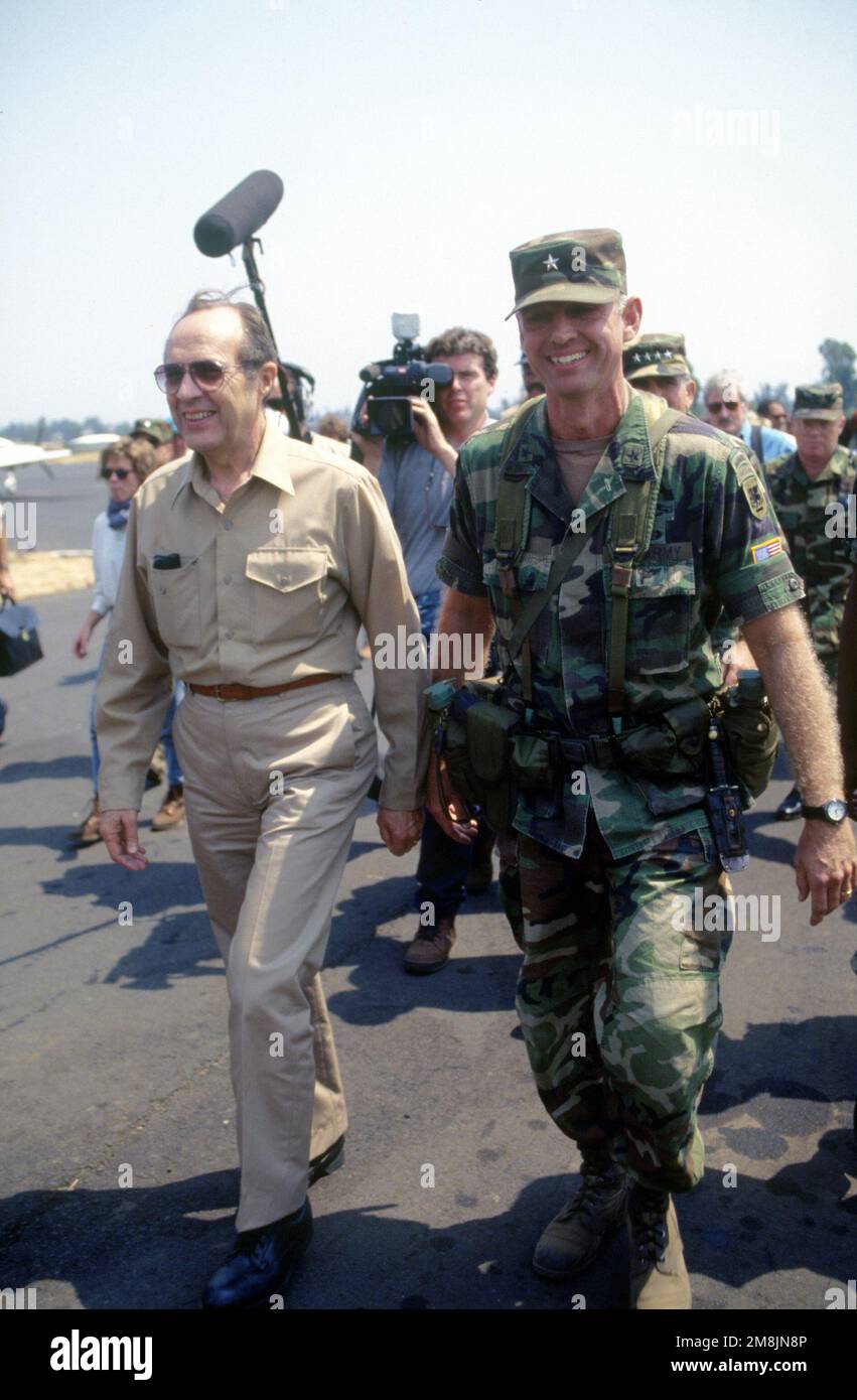 U.S. Secretary of Defense William Perry walks with BGEN Jack Nix during ...