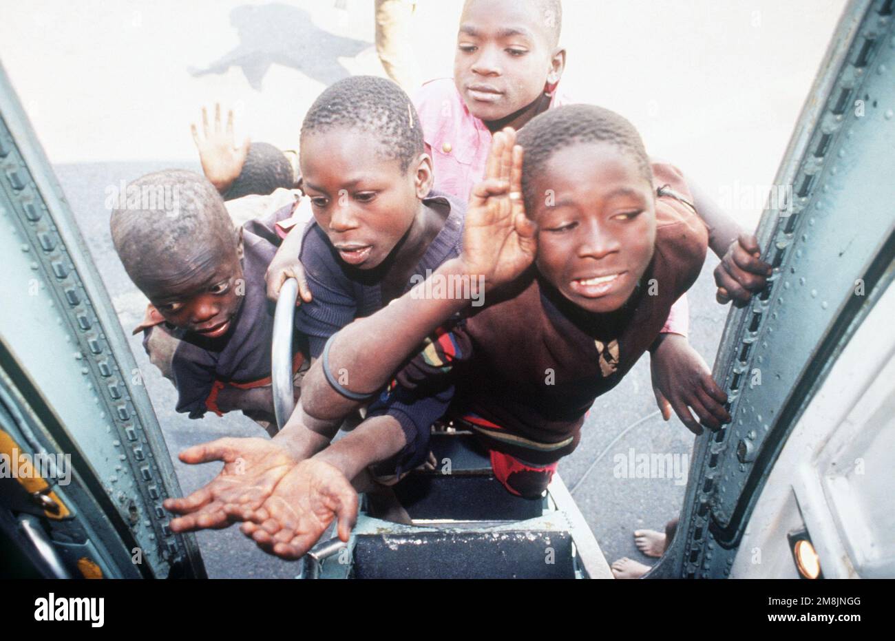 Rwandan children beg for food and water at the doorway of a C-141 ...