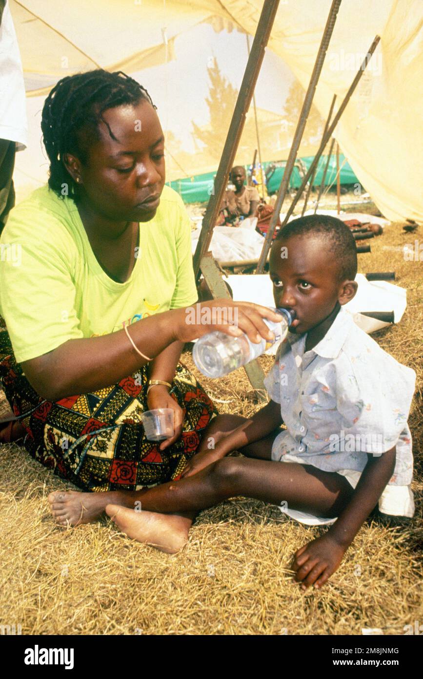 A mother gives her child water at the Kitali refugee camp. Subject ...