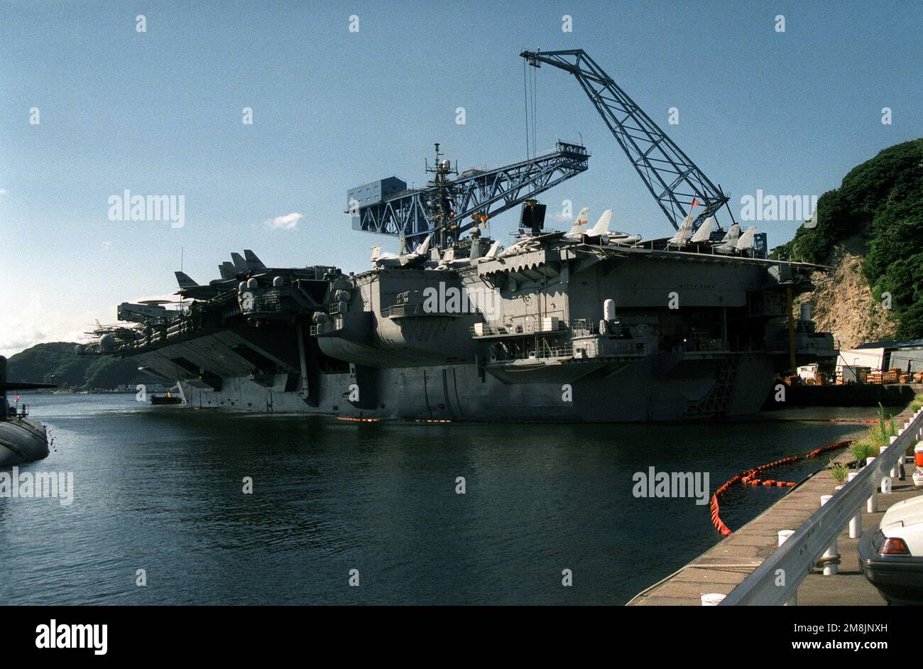 A port quarter view of the aircraft carrier USS KITTY HAWK (CV-63) tied up at the Piedmont Pier ...