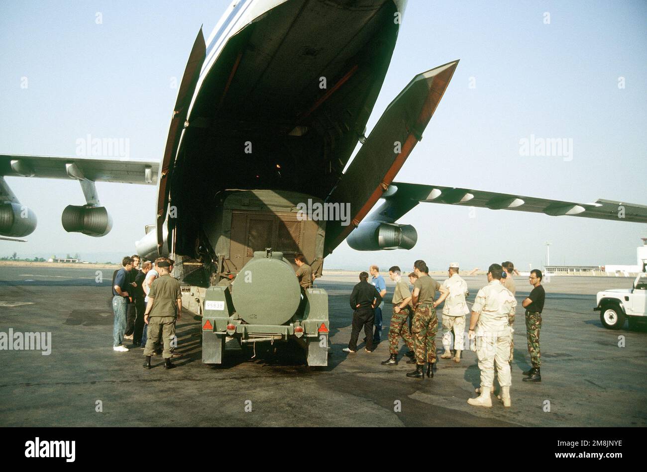 Ground support personnel off load Canadian equipment and supplies from ...