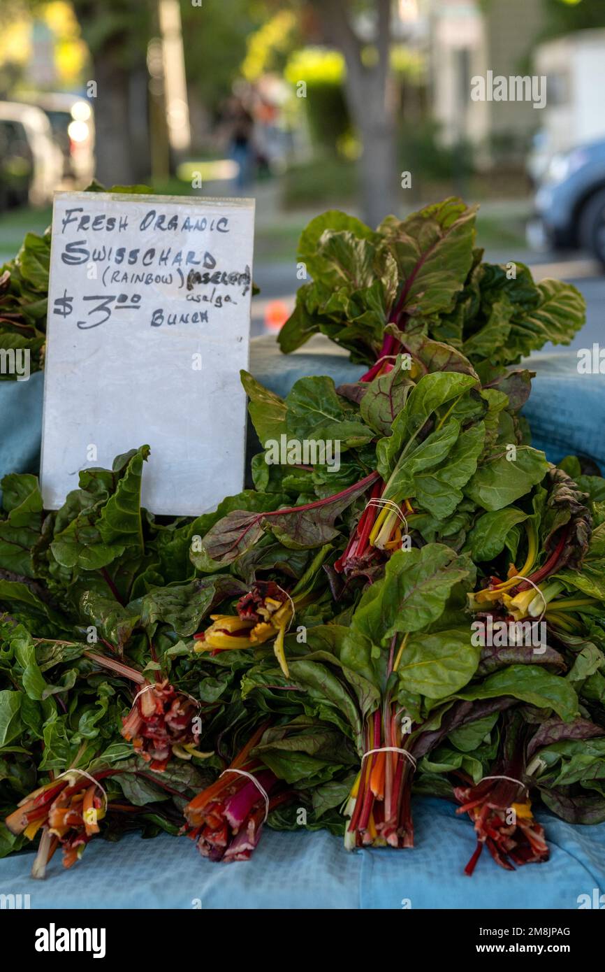 Fresh organic Swiss chard (Rainbow) in a farmers market with a sign ...