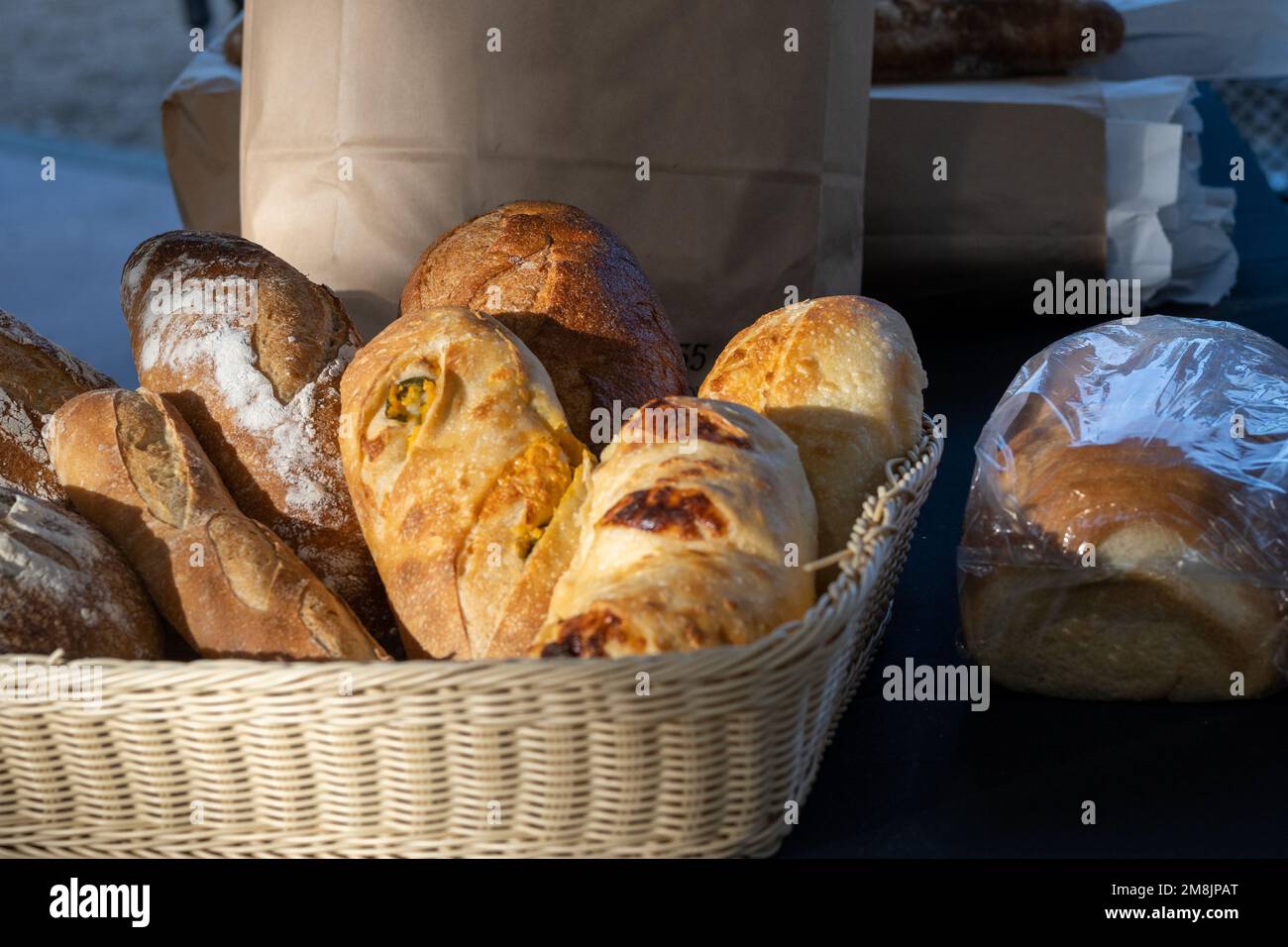 A basket of bread at a farmers market viwed from the side under natural ...