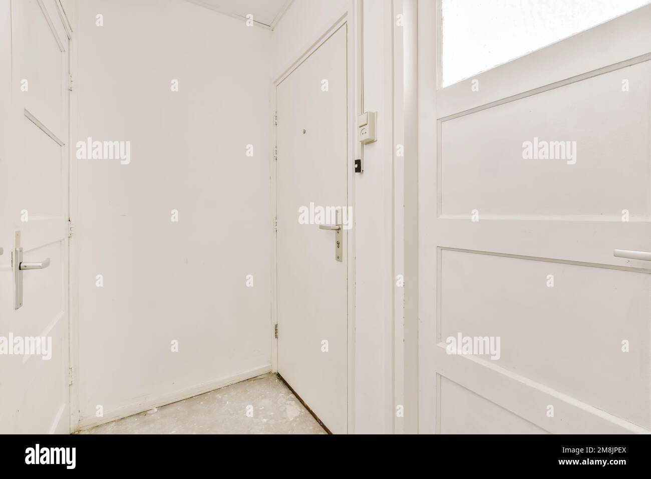 an empty room with white walls and wooden doors on either side, there ...
